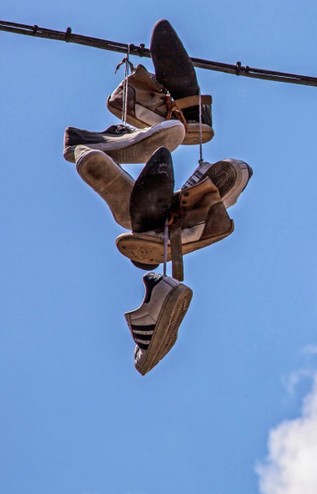 El enigma urbano: ¿Qué significan las zapatillas colgadas en los cables ...